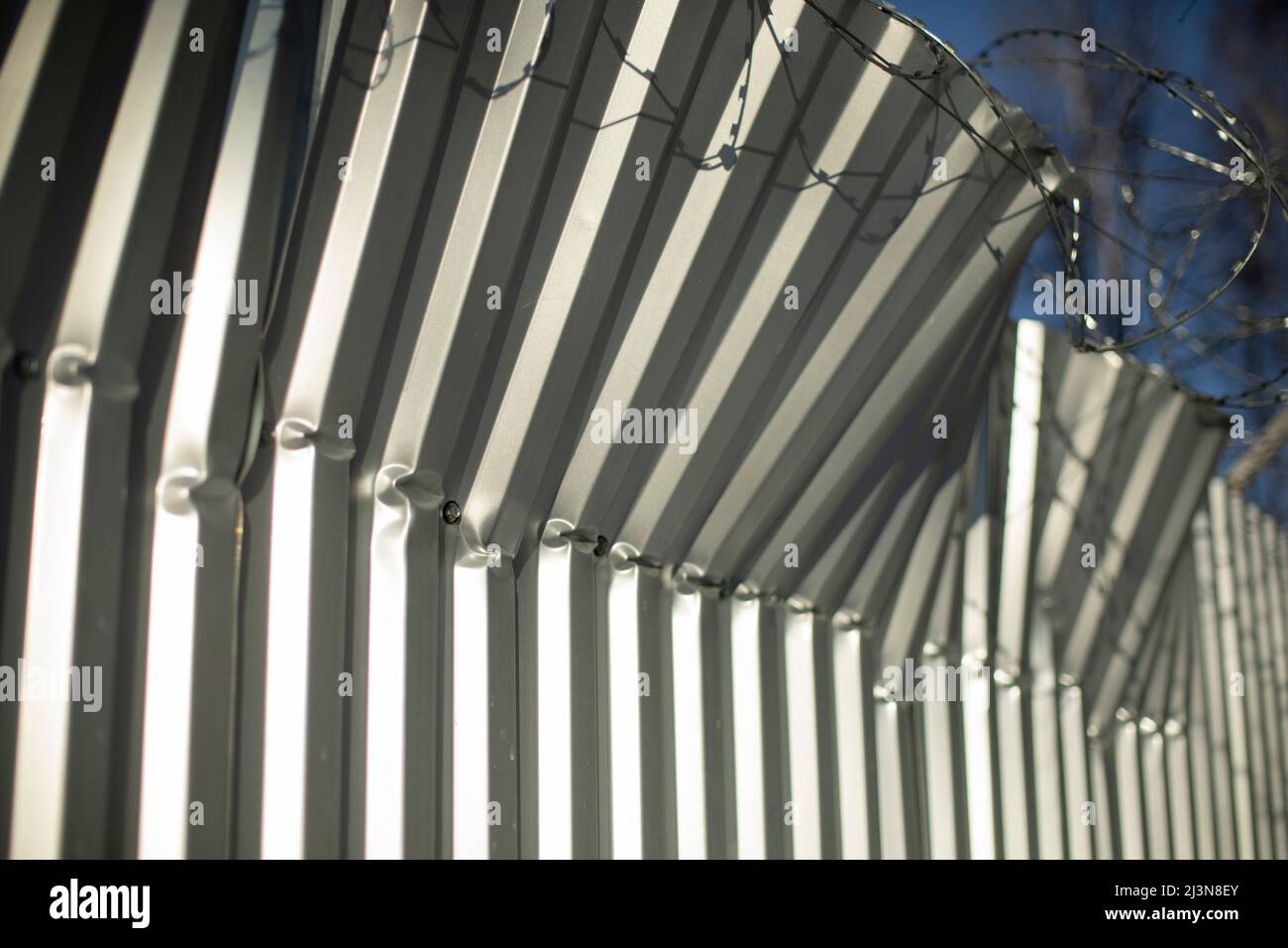 Broken fence. Fence from profile sheet bent. Rumpled iron. Damage to ...