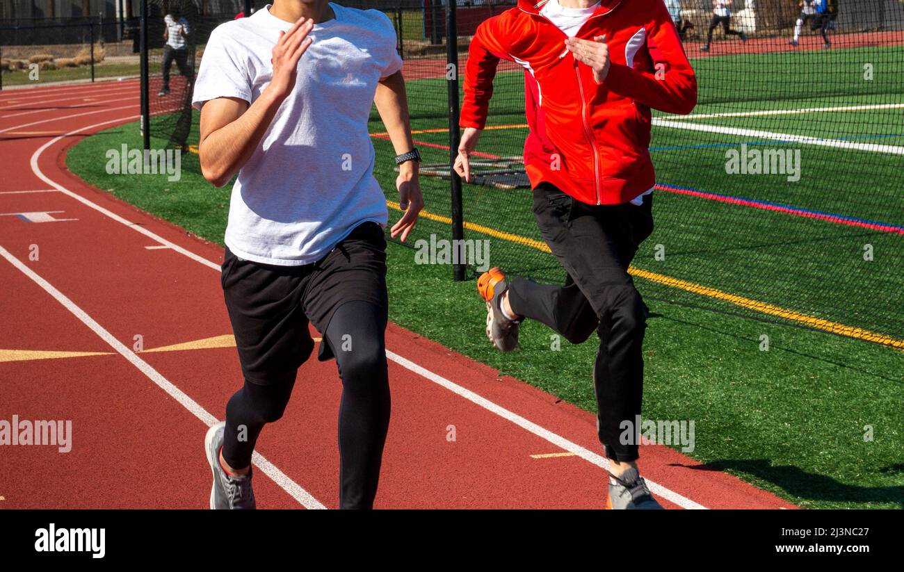 High school boys running two by two at track and field practice on a ...