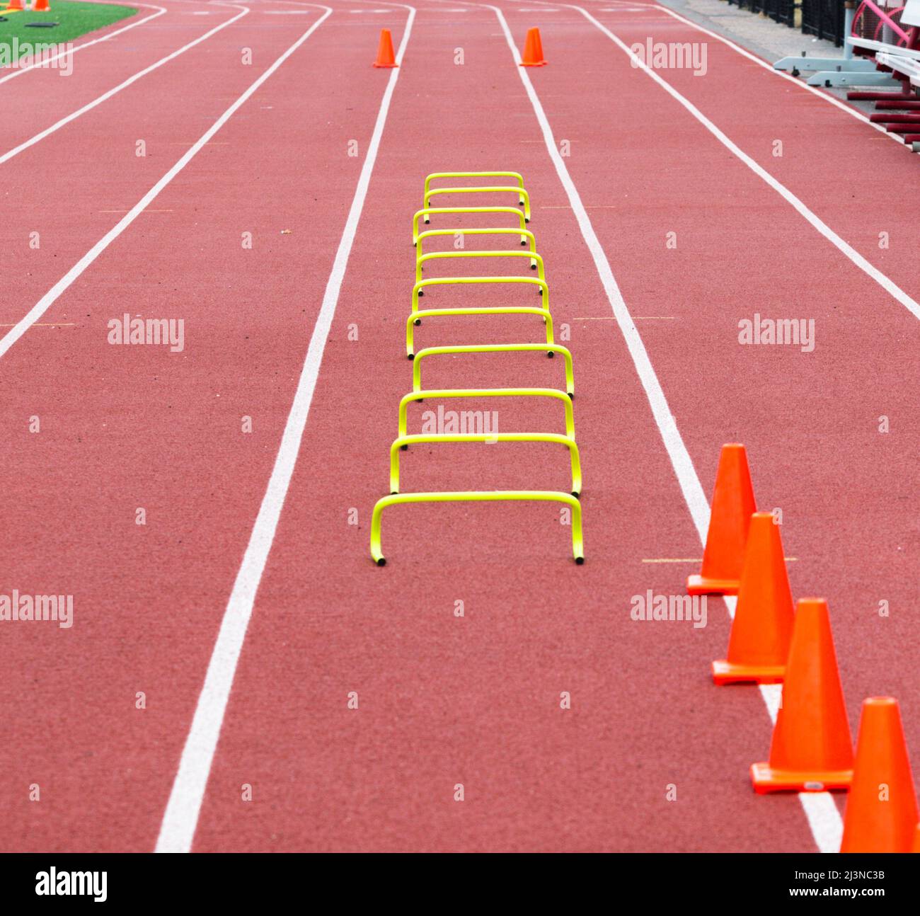 Eleven six inch high yellow plastic hurdles set up in lane four for ...