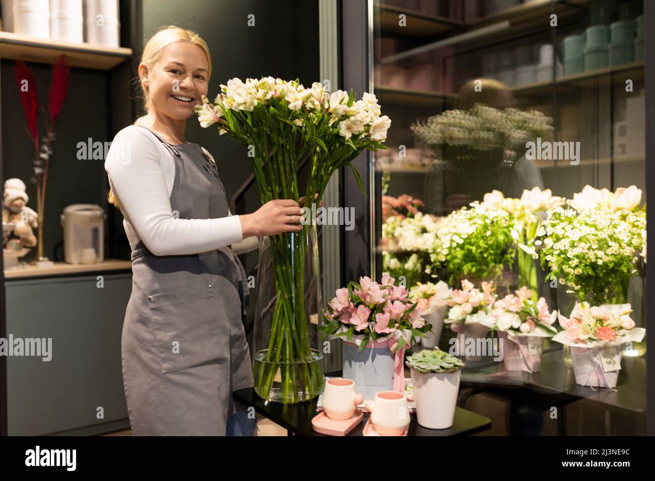 flower shop employee next to a refrigerator with fresh flowers for ...