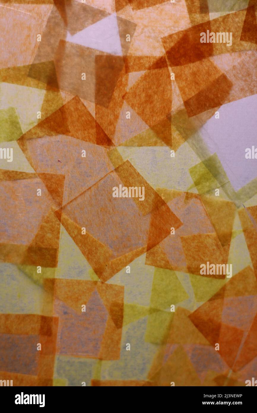 Craft tissue paper glued to a window as an abstract orange translucent ...