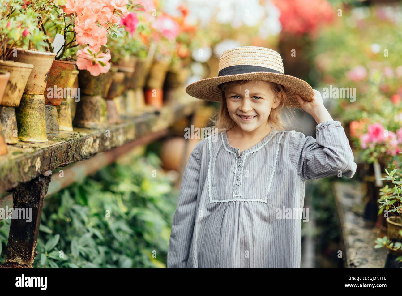 Child planting spring flowers. Little girl gardener plants azalea. Girl ...