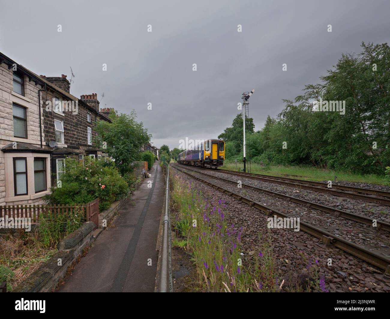 Northern Rail class 153 + class 155 train passing terraced houses and a ...