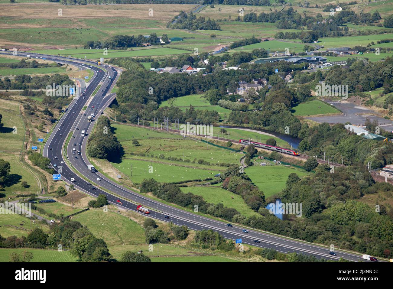 Train on the west coast mainline passing the M6 Tebay interchange ...