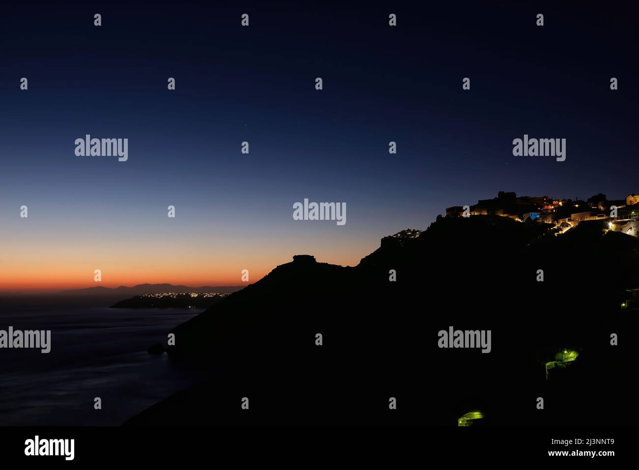 Panoramic view of the illuminated village of Fira, Oia and a ...