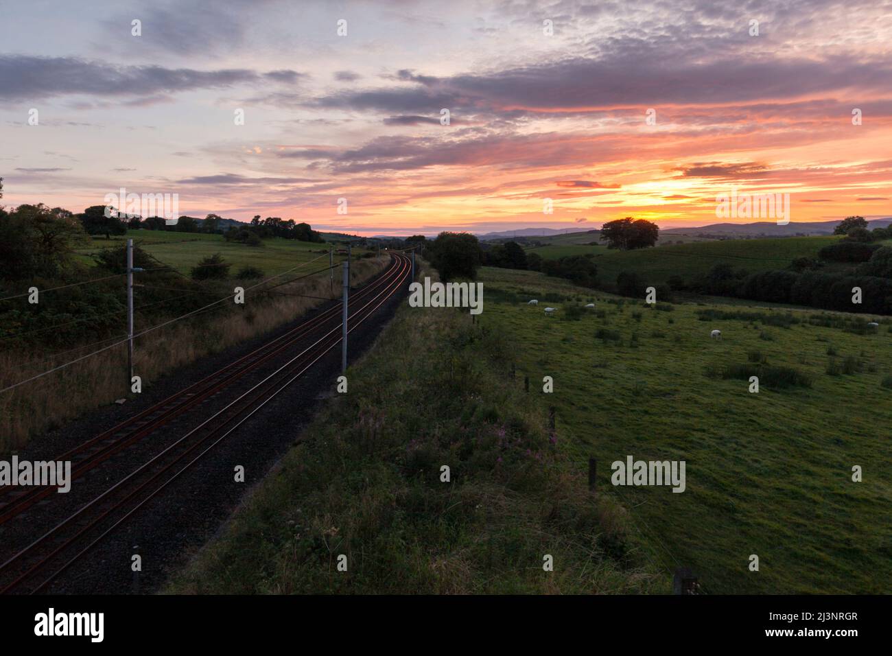 West coast mainline railway at Grayrigg Cumbria with the sun setting ...