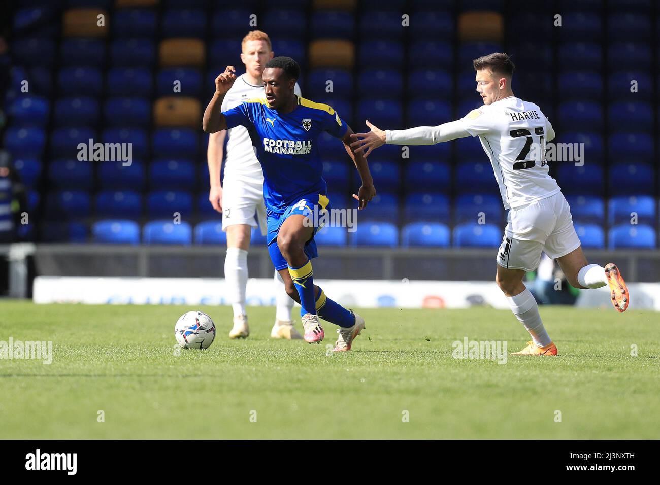 Zach Robinson #14 of AFC Wimbledon evades Daniel Harvie #21 of Milton ...