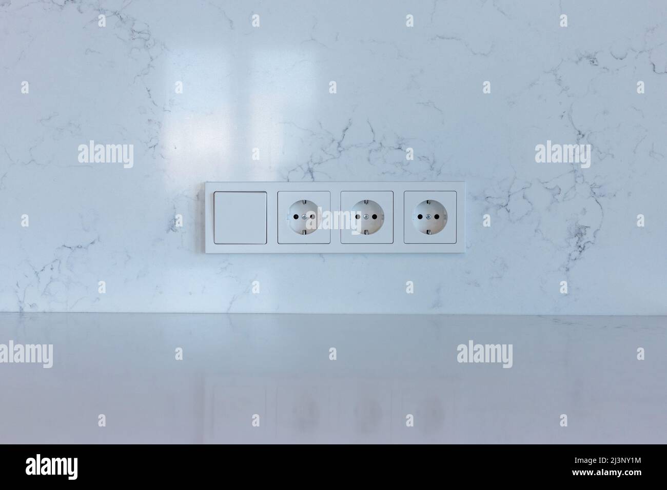 Block of three sockets and a switch on a white wall Stock Photo - Alamy