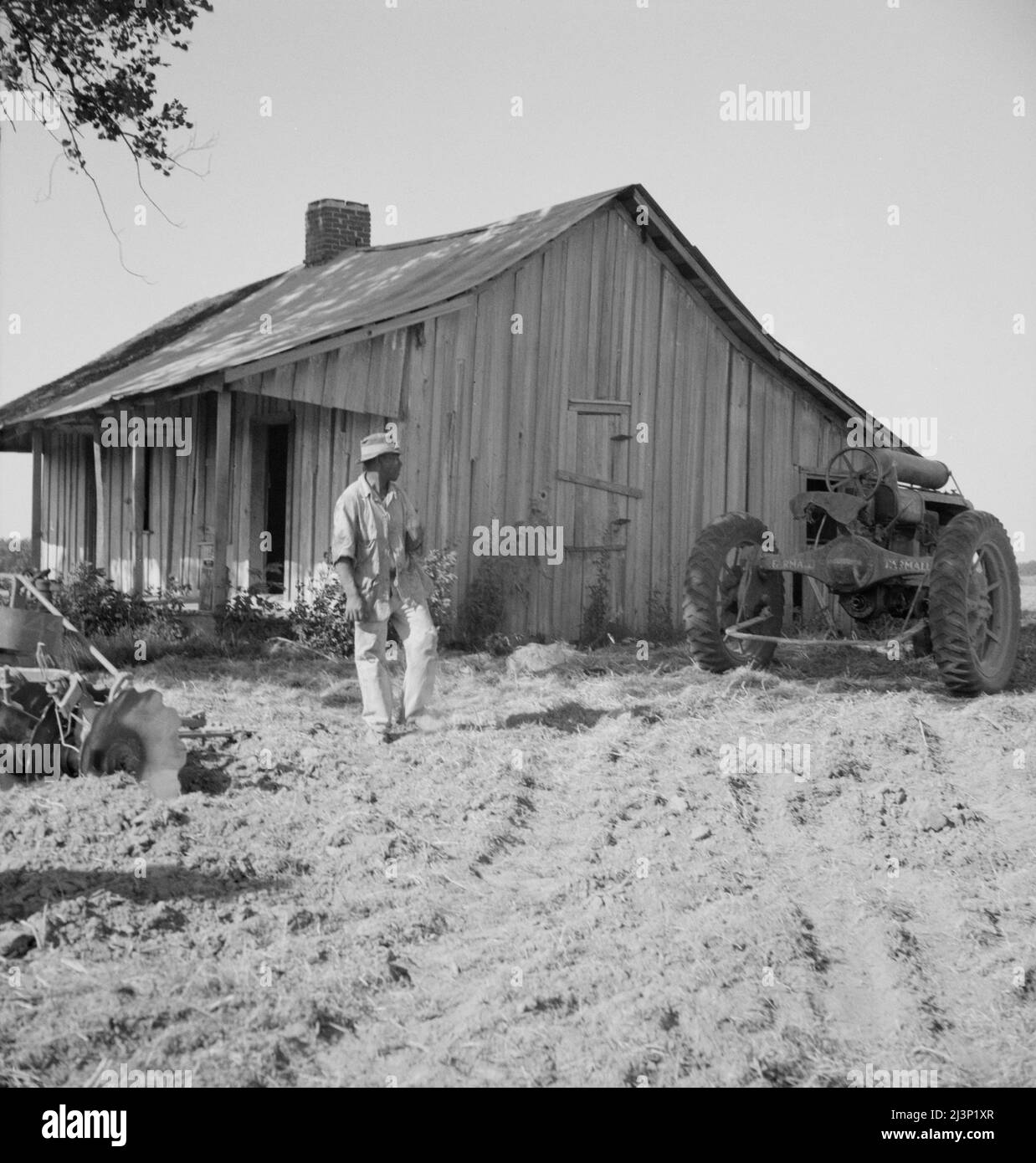 Colored tractor driver and empty cabin on mechanized cotton plantation ...