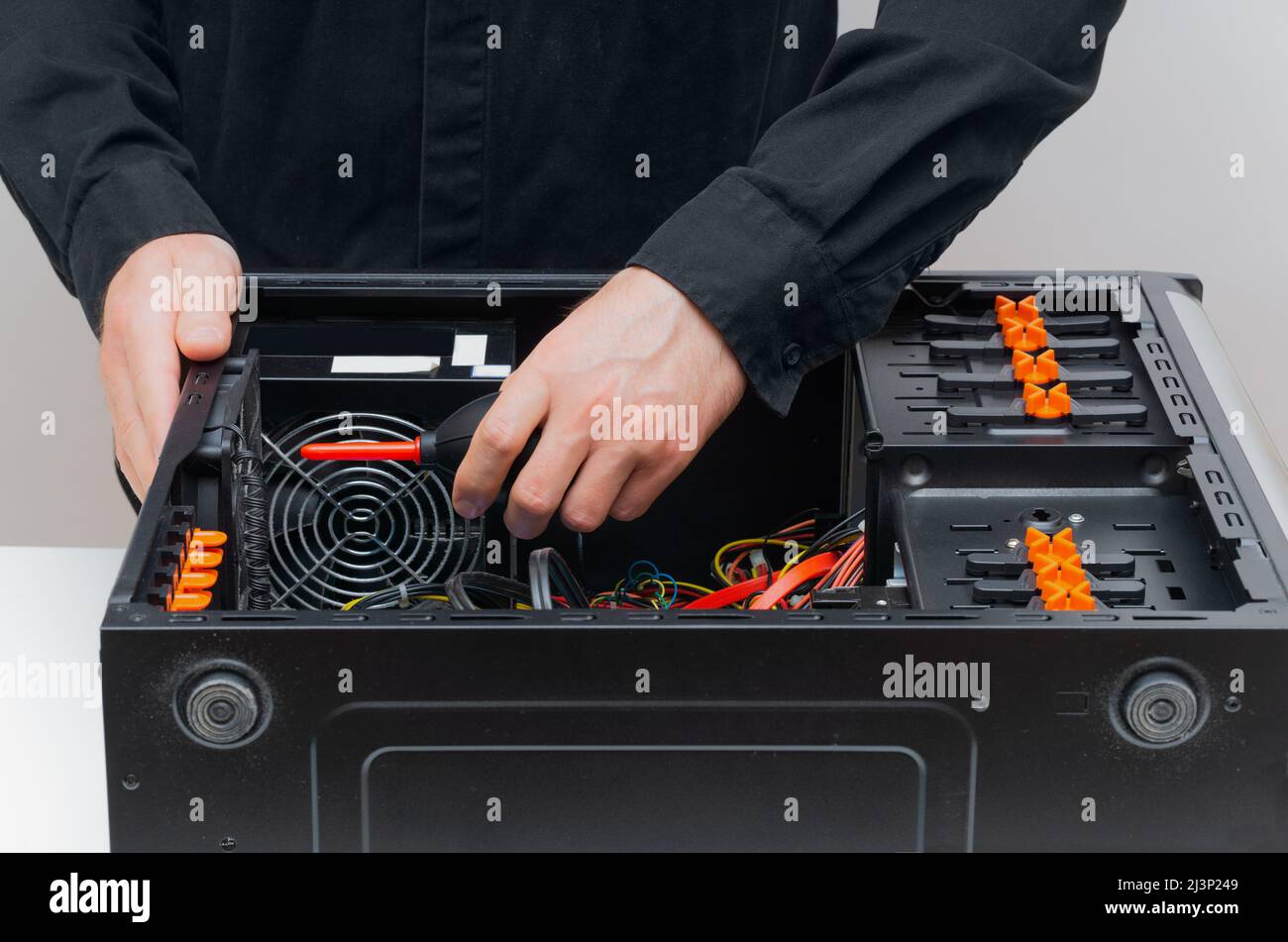 Man wearing a black long sleeve shirt cleaning a personal computer with ...