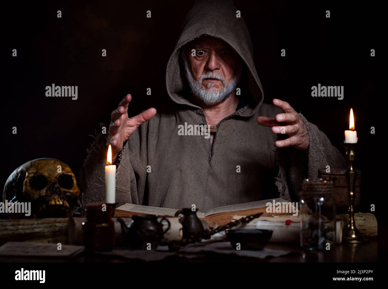 Merlin conjures with magic book Stock Photo - Alamy