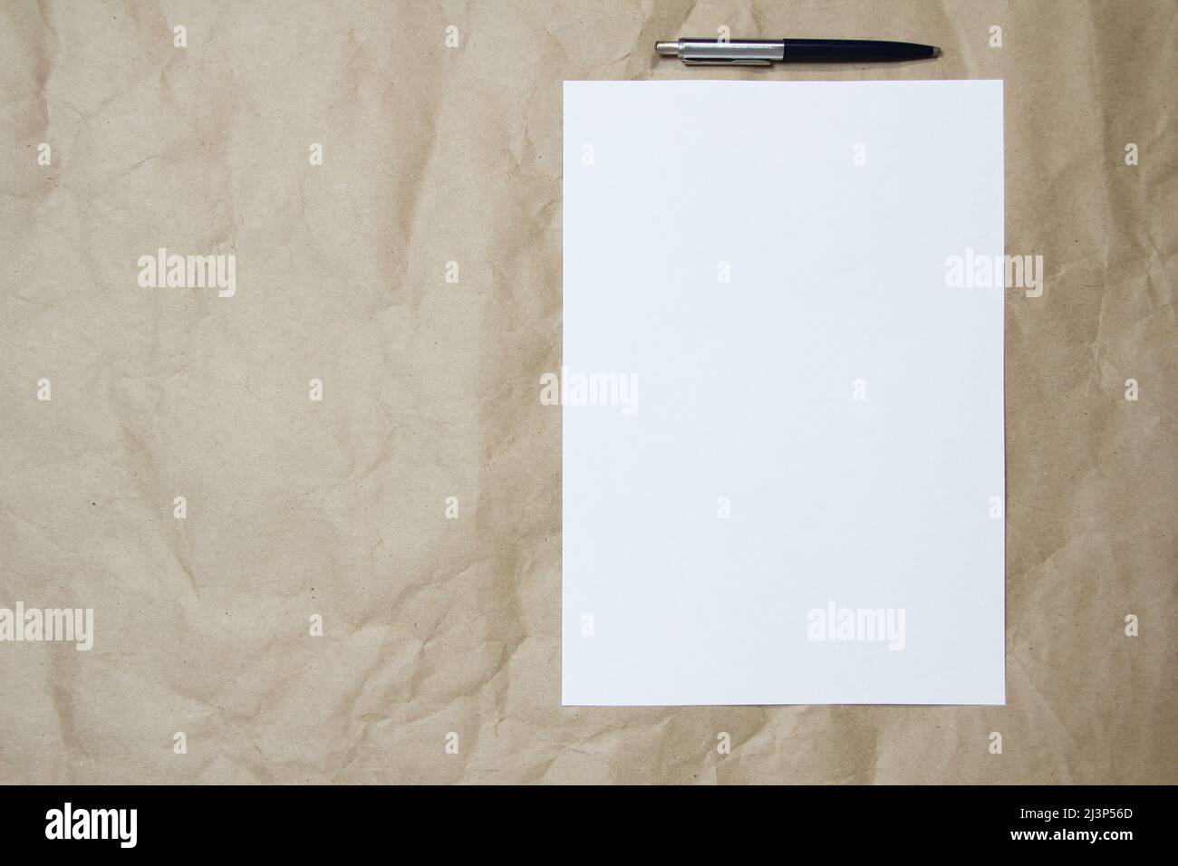 White empty sheet of A4 format with pen on a beige craft paper. Concept ...