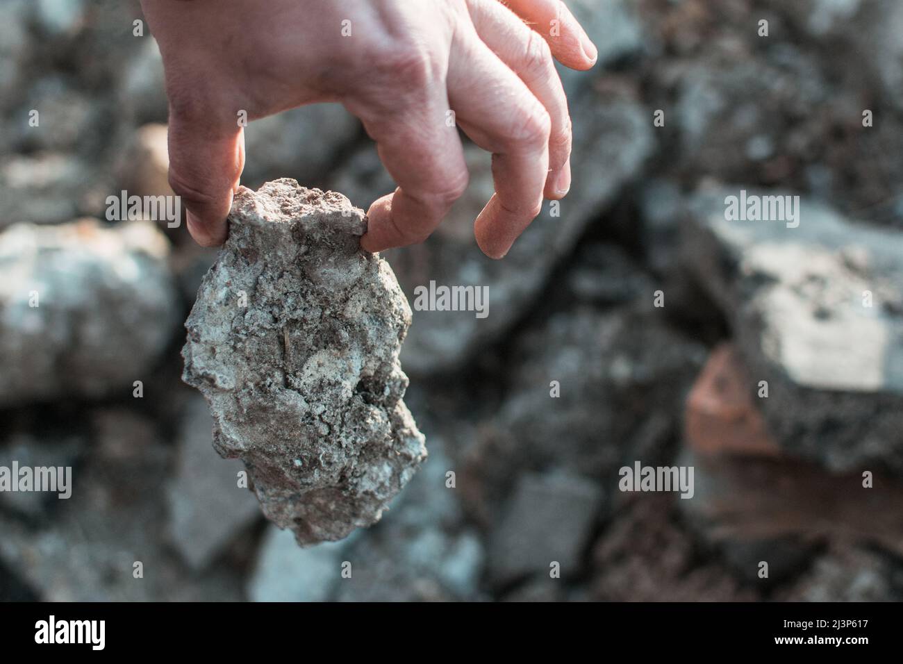 Male hand holding a stone Stock Photo - Alamy