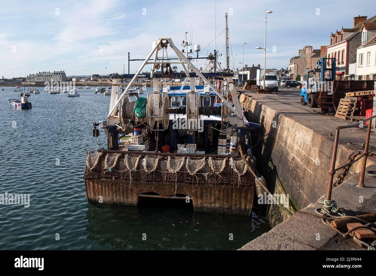 Fishing boat moored on a quay in town Stock Photo - Alamy