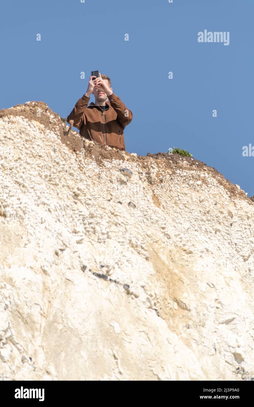 Cliff edge danger, People stand precariously close to the cliff edge at ...