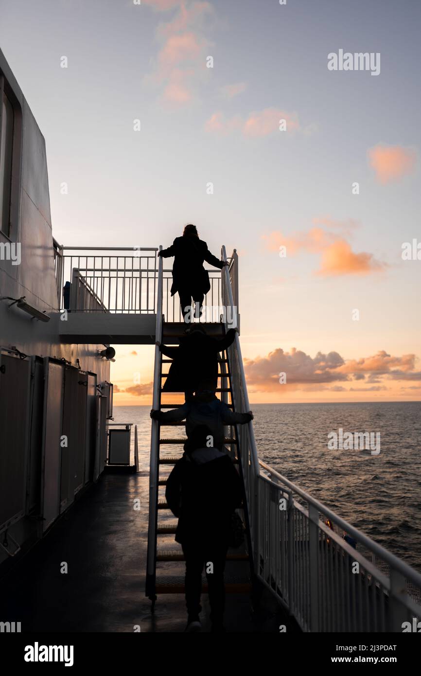 Beautiful sunset sky on ferry boat with anonymous passengers climbing ...