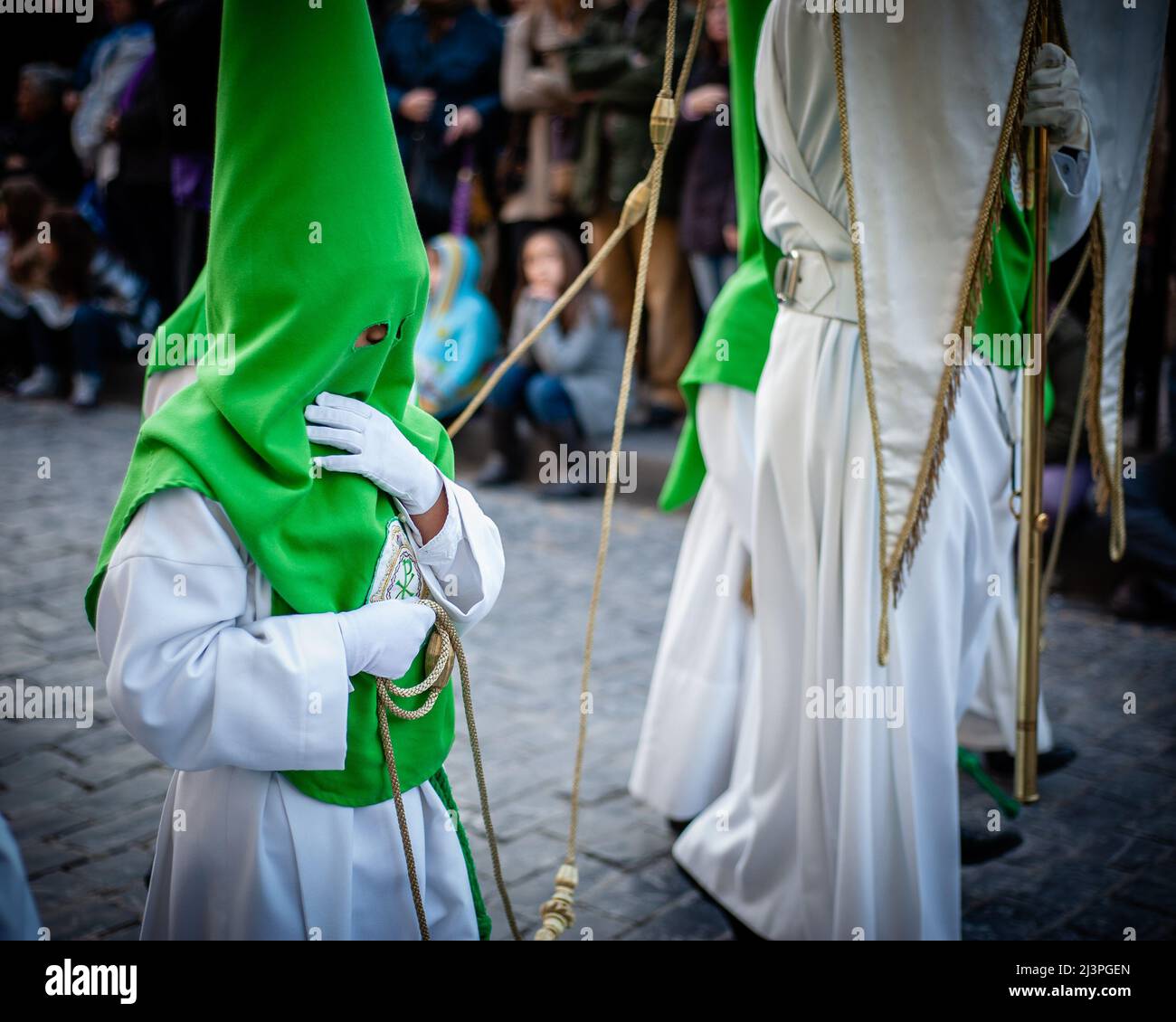 A little child is seen wearing the typical capirote (a huge mask to ...