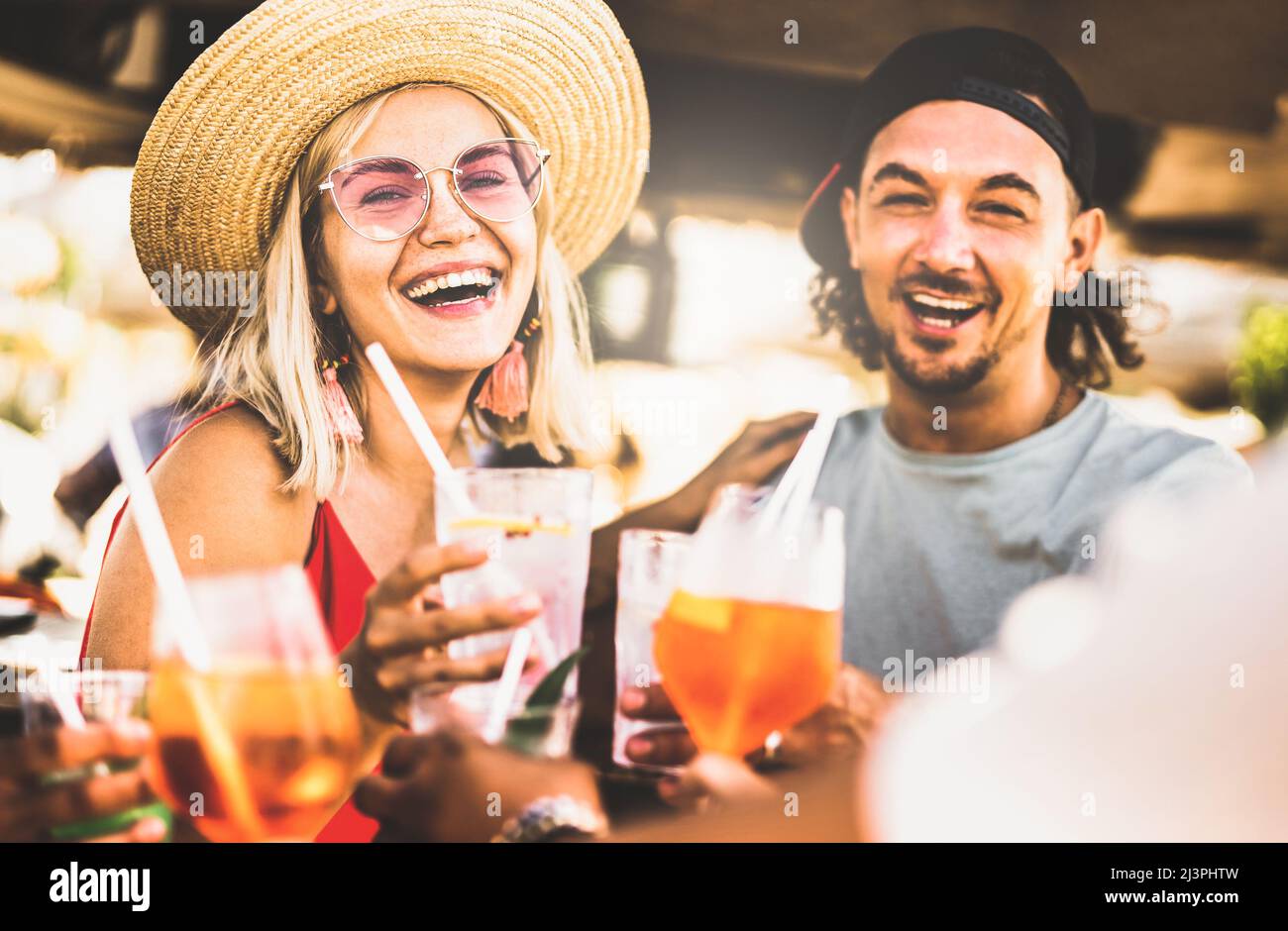 Trendy couple having fun drinking fancy cocktails at beach party ...