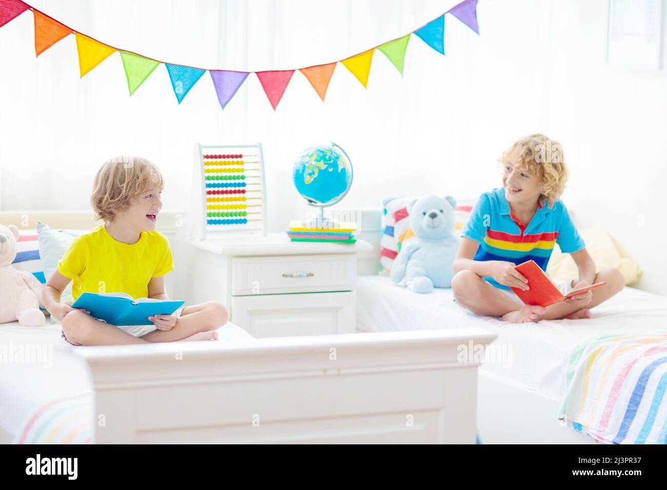 Child reading book in bed. Bedroom for two kids. Little boys read books ...