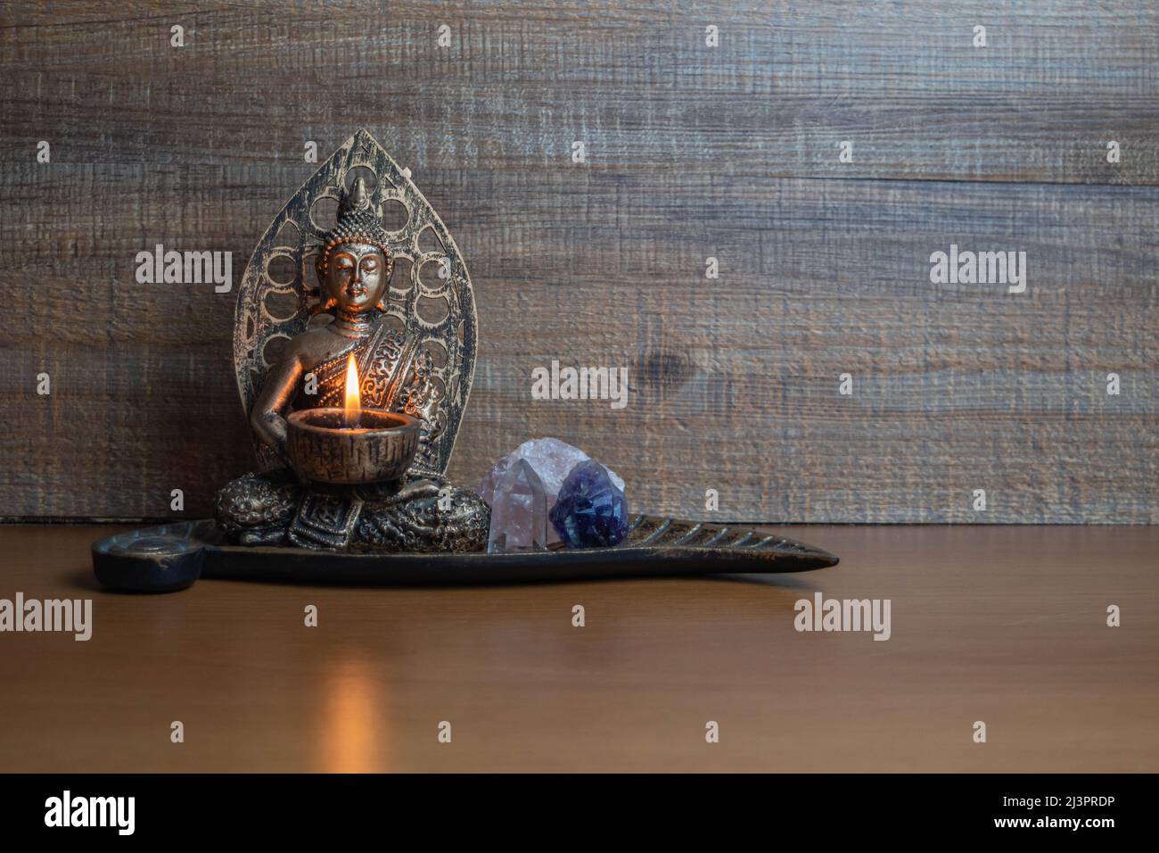 Buddha craft in meditation posture with candle Stock Photo - Alamy