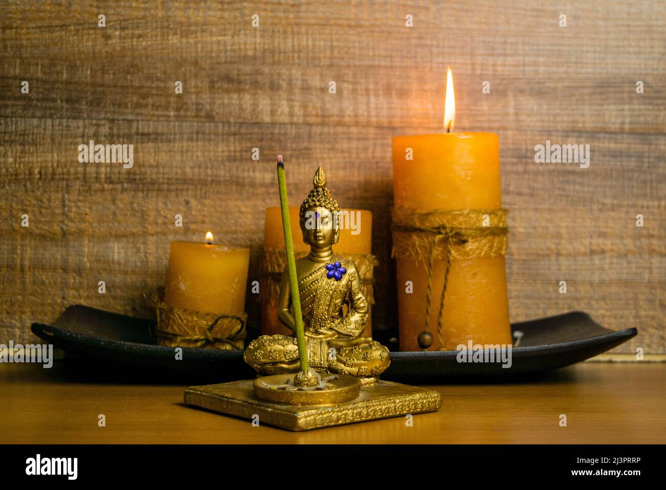 Buddha craft in meditation posture with candle Stock Photo - Alamy