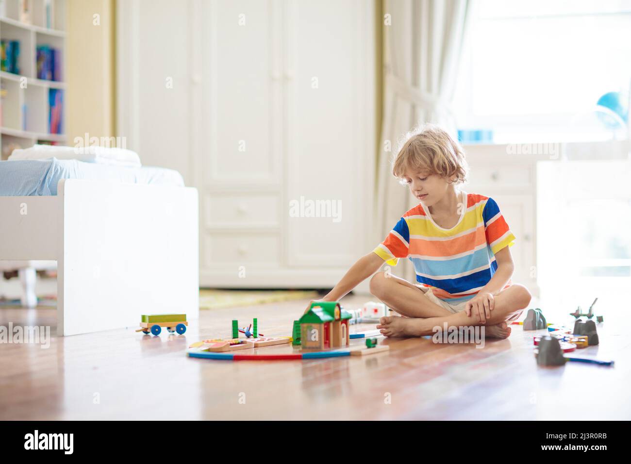 Kids play with wooden railway. Child with toy train. Educational toys ...