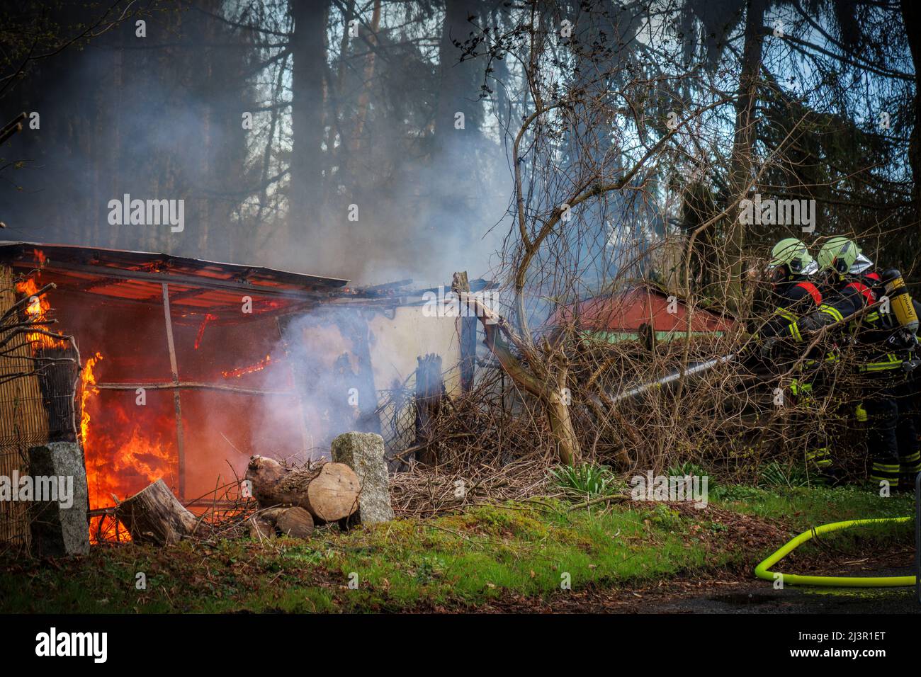 the fire department extinguishes a garden house that has caught fire ...