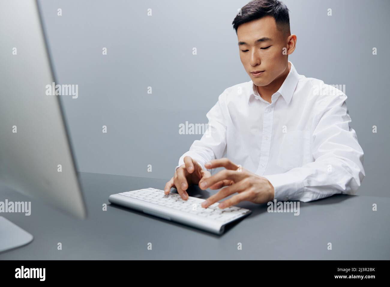 businessmen sit at a desk in front of a computer isolated background ...