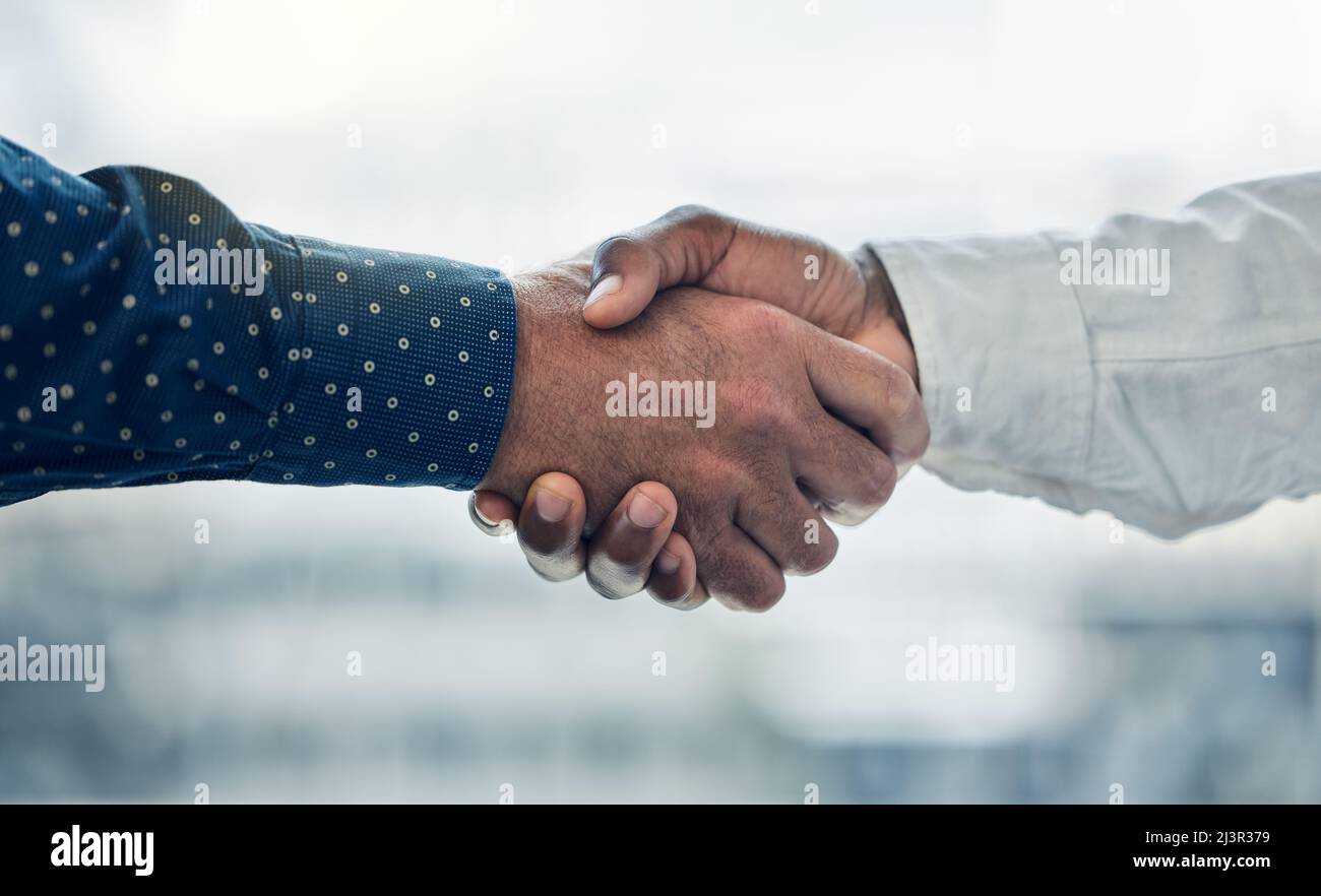 Im glad to have you on board. Shot of two colleagues shaking hands in ...