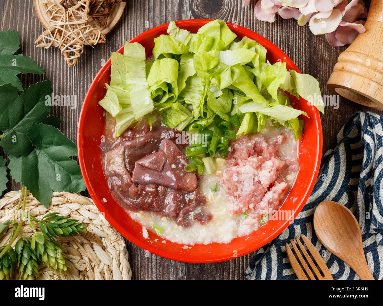 Pork liver and lean meat porridge in a bowl top view on wooden table ...
