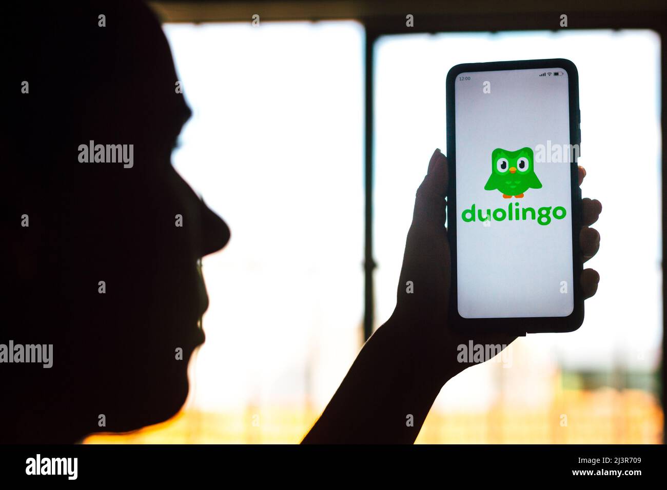 In this photo illustration, a woman's silhouette holds a smartphone ...