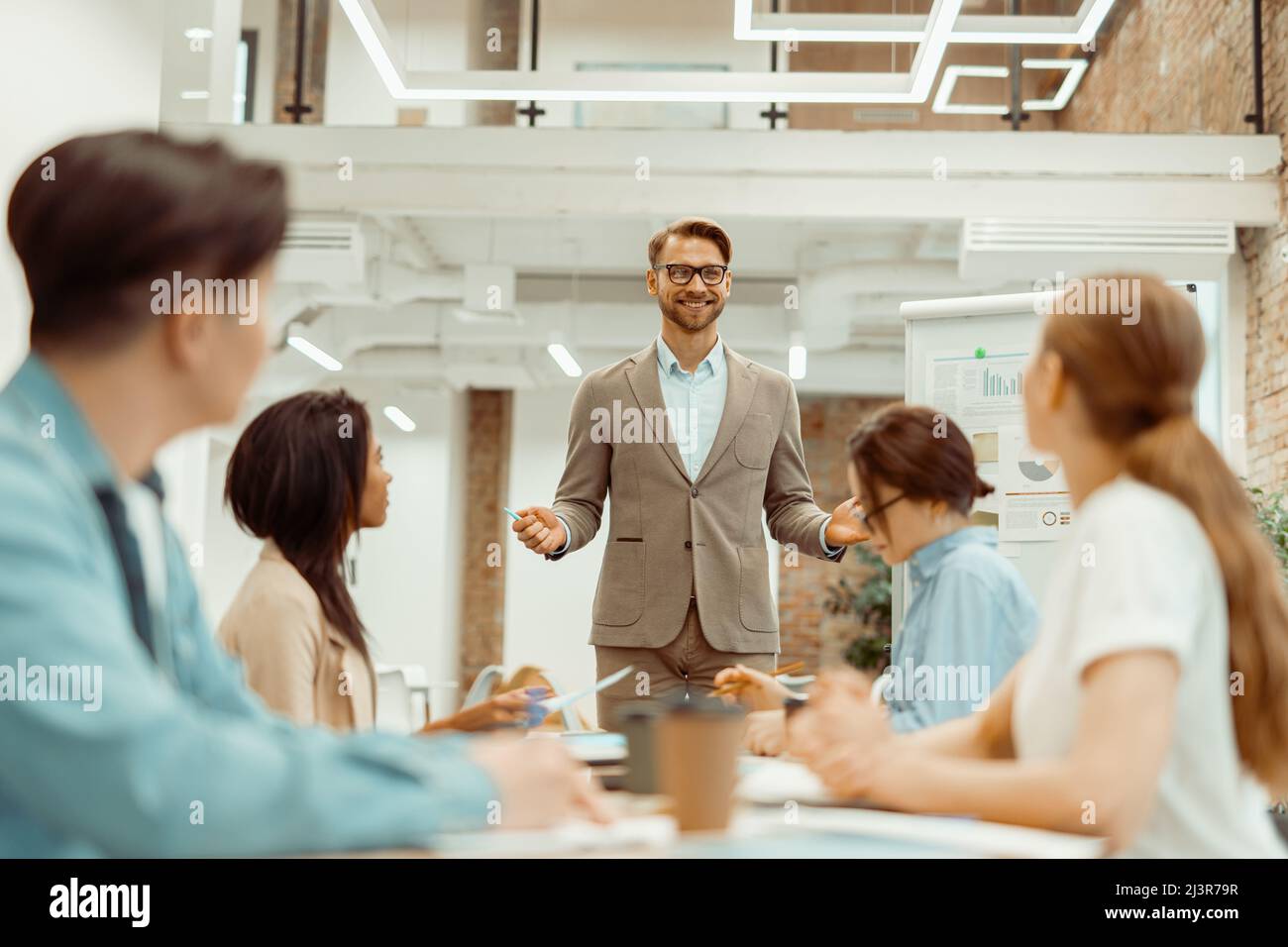 Colleague making a presentation while standing in the office Stock ...