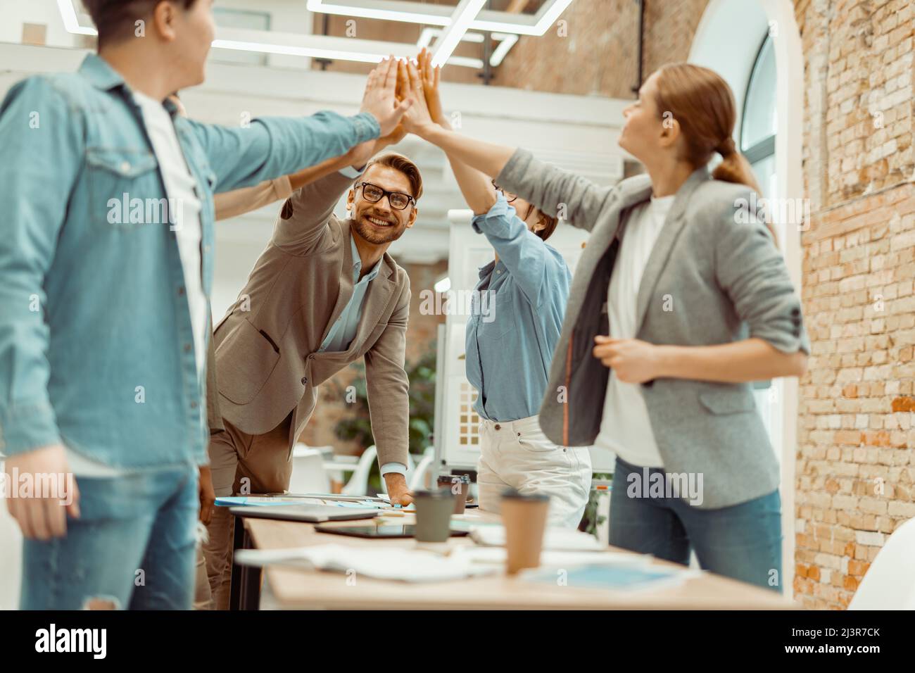Smiling colleagues showing team work in office Stock Photo - Alamy