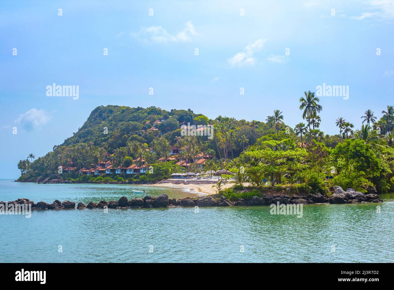 Mountain cape in the sea with holiday houses, a small sandy beach on a ...