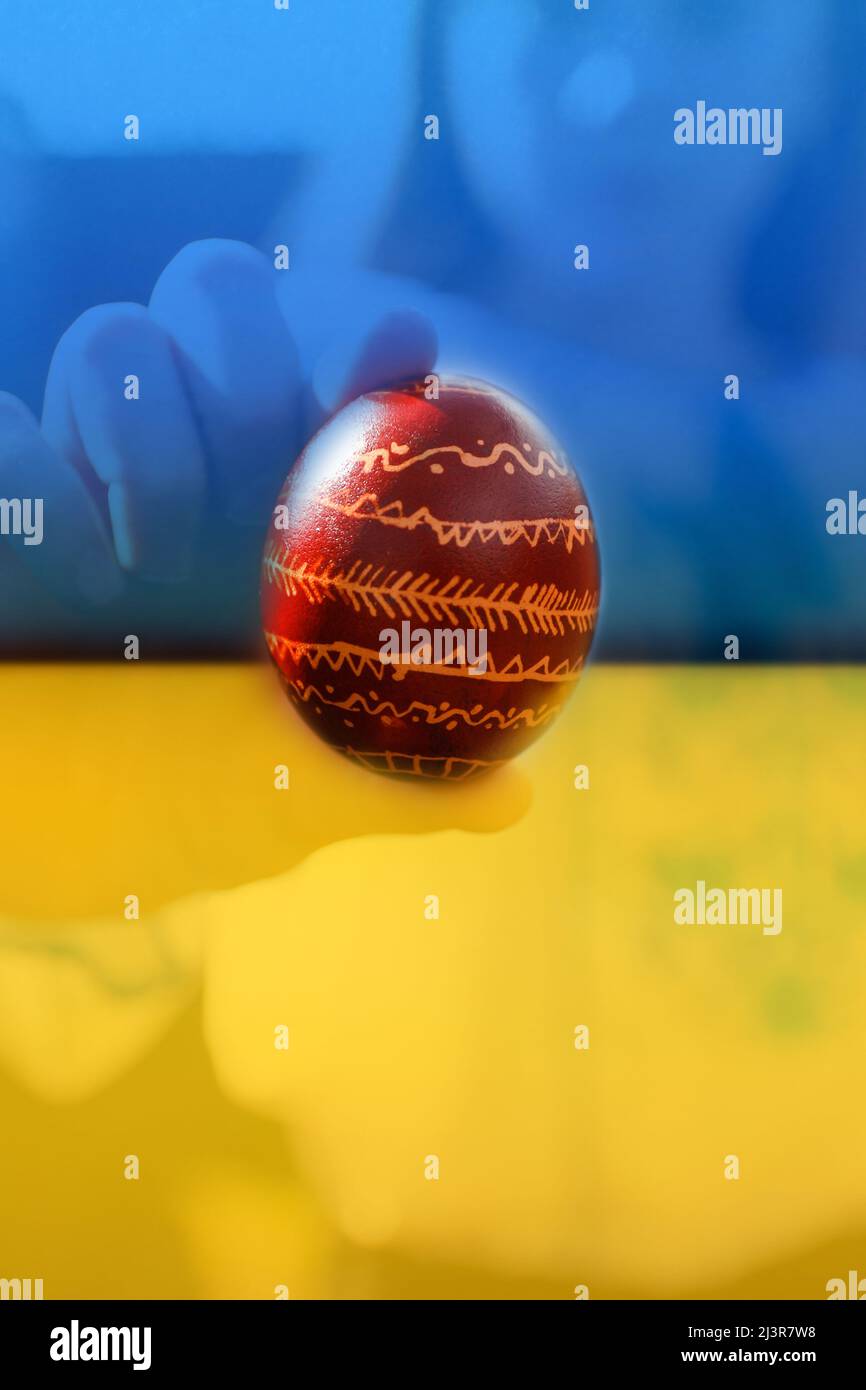 Defocus ukrainian girl in vyshyvanka holding one colored red egg on ...