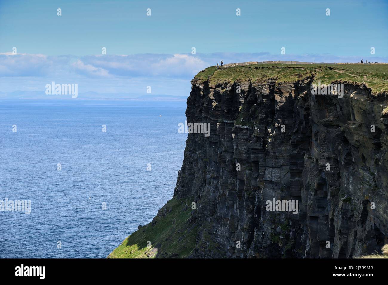 People near the edge of the Cliffs of Moher, sea cliffs located at the ...