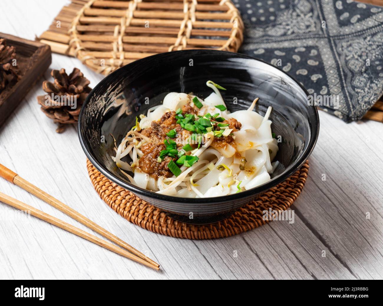 Big Kway Teow dry in a dish isolated on wood table side view taiwan ...