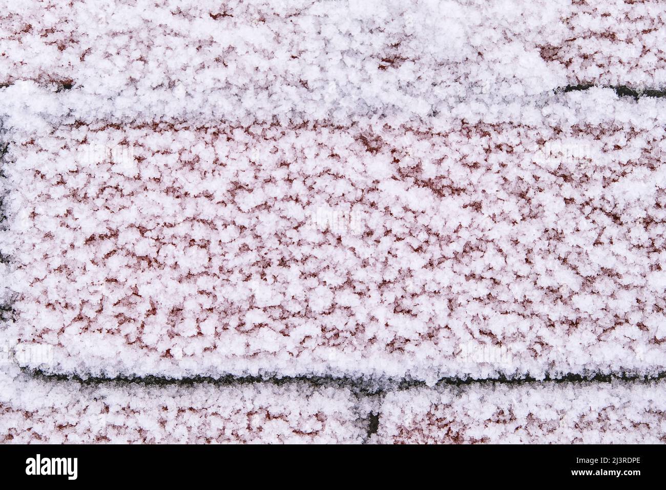 The brick wall is covered with snow patterns. Frost on the brick ...