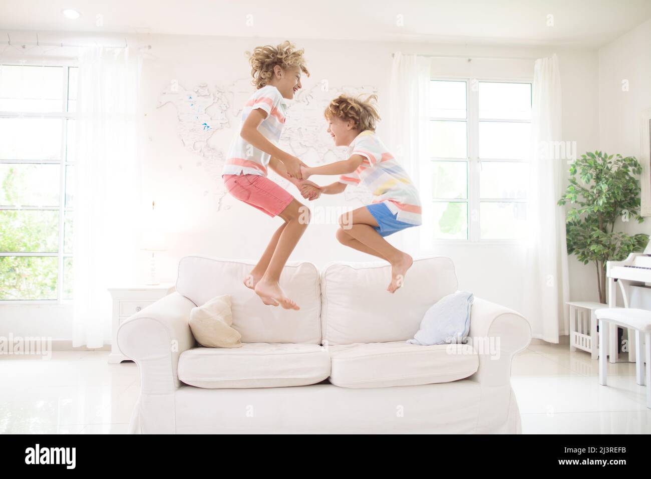 Child is jumping on the sofa in the living room hi-res stock ...
