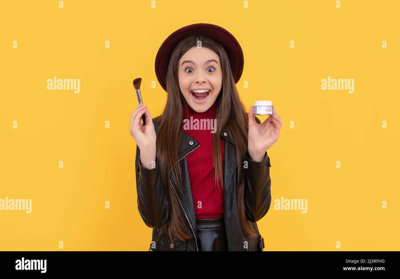 presenting female cosmetic product. amazed child apply face powder ...