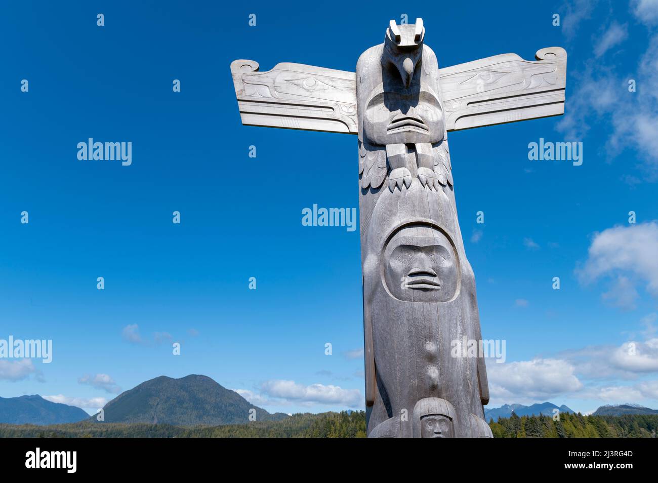 Carved totem pole in the beautiful Tofino with Meares Island in the ...
