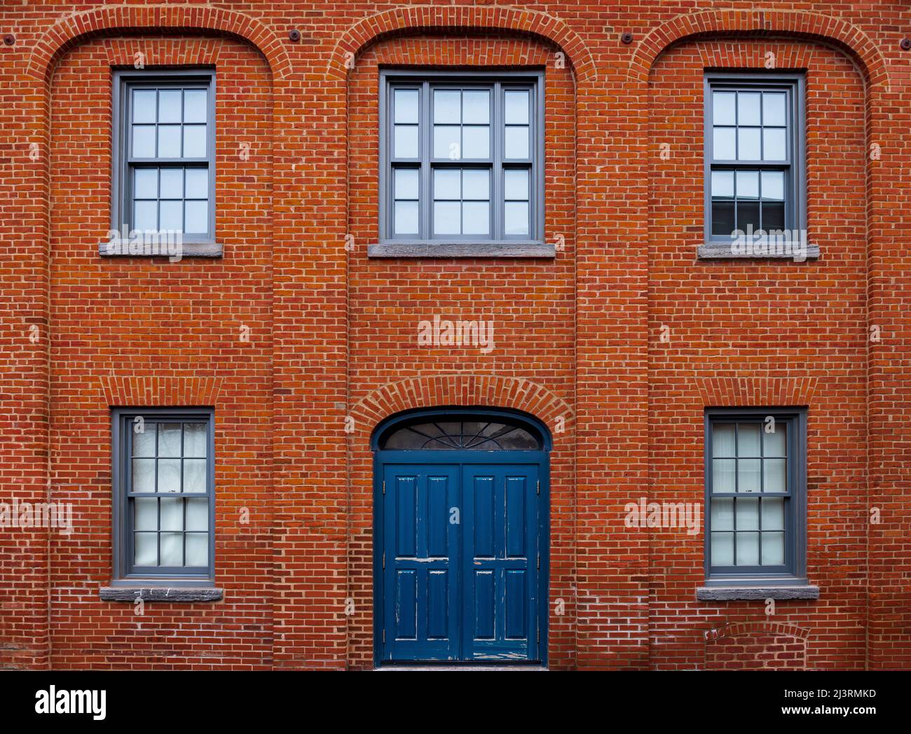 Brick building with a blue entrance door Stock Photo - Alamy