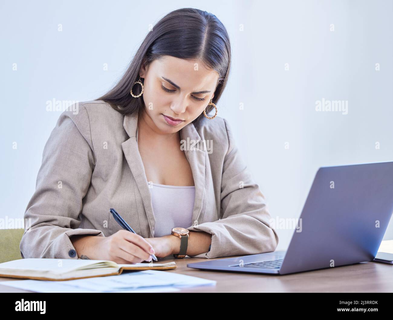 Updating her diary with some important notes. Shot of a young ...