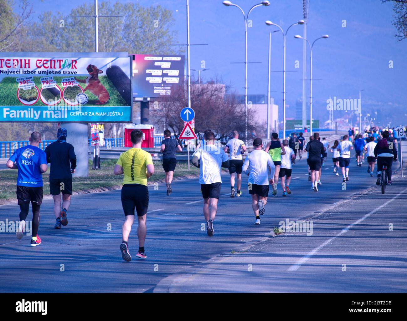 Rear view of group of people running street marathon Stock Photo - Alamy