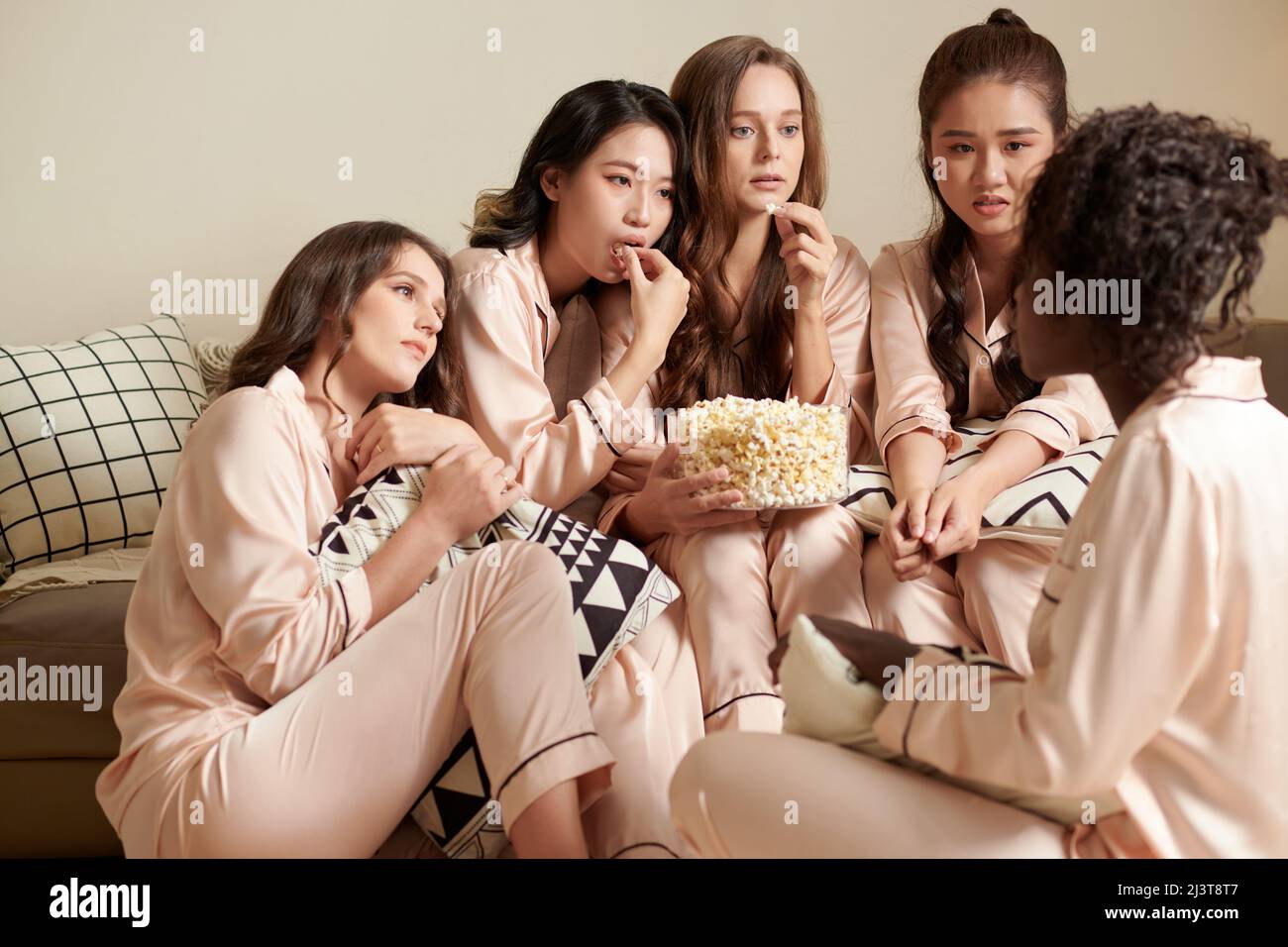 Sad empathic young women eating popcorn when listening to breakup story ...