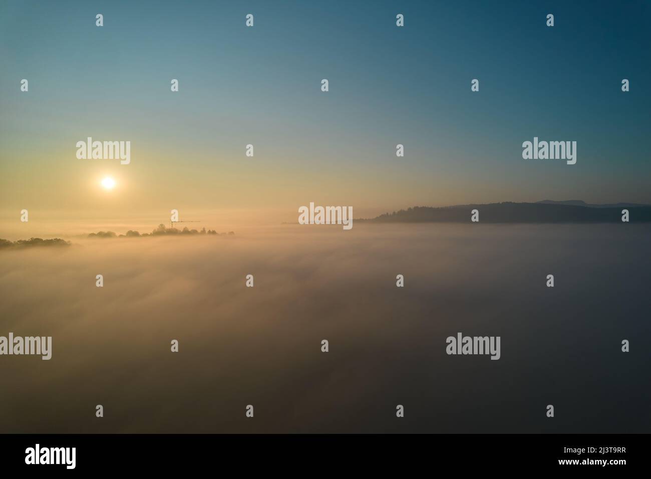 Landscape shot above the fog. Yellow sun rising on horizon. Panorama ...