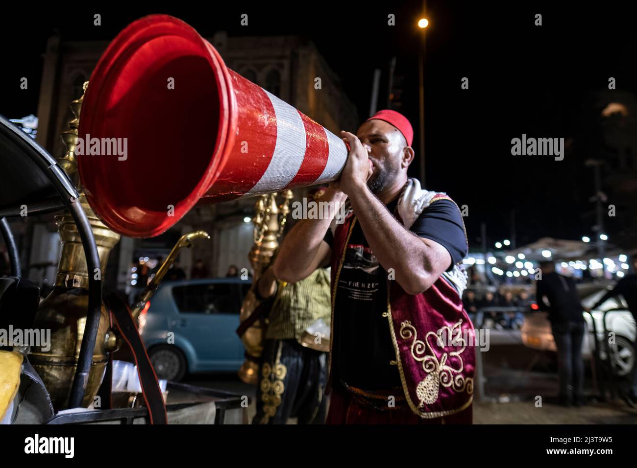 A Palestinian tamarind Juice vendor uses a plastic traffic cone to ...