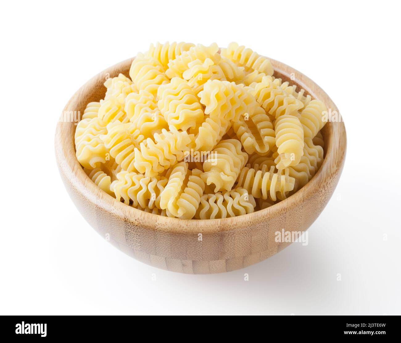 Uncooked radiatori pasta in wooden bowl isolated on white background ...
