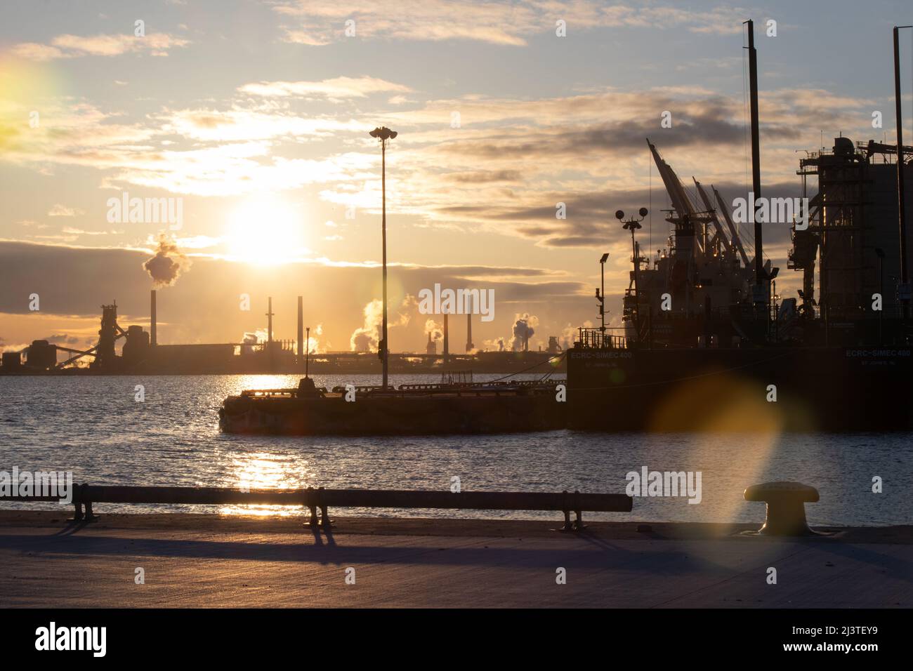The early morning sun shines down on the industrial coastline in ...