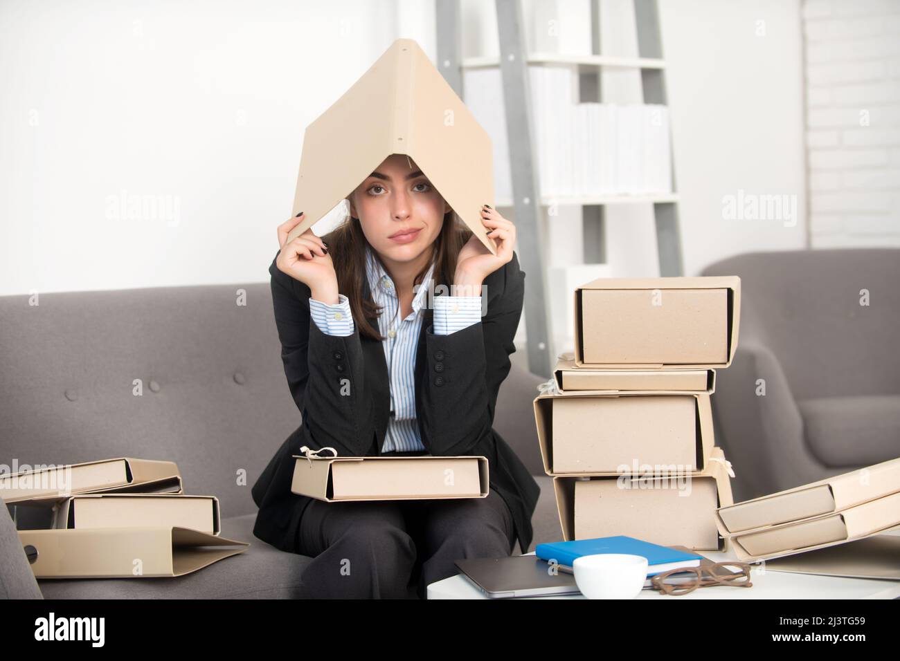 Sad busy secretary with many folders of documents, stressed overworked ...